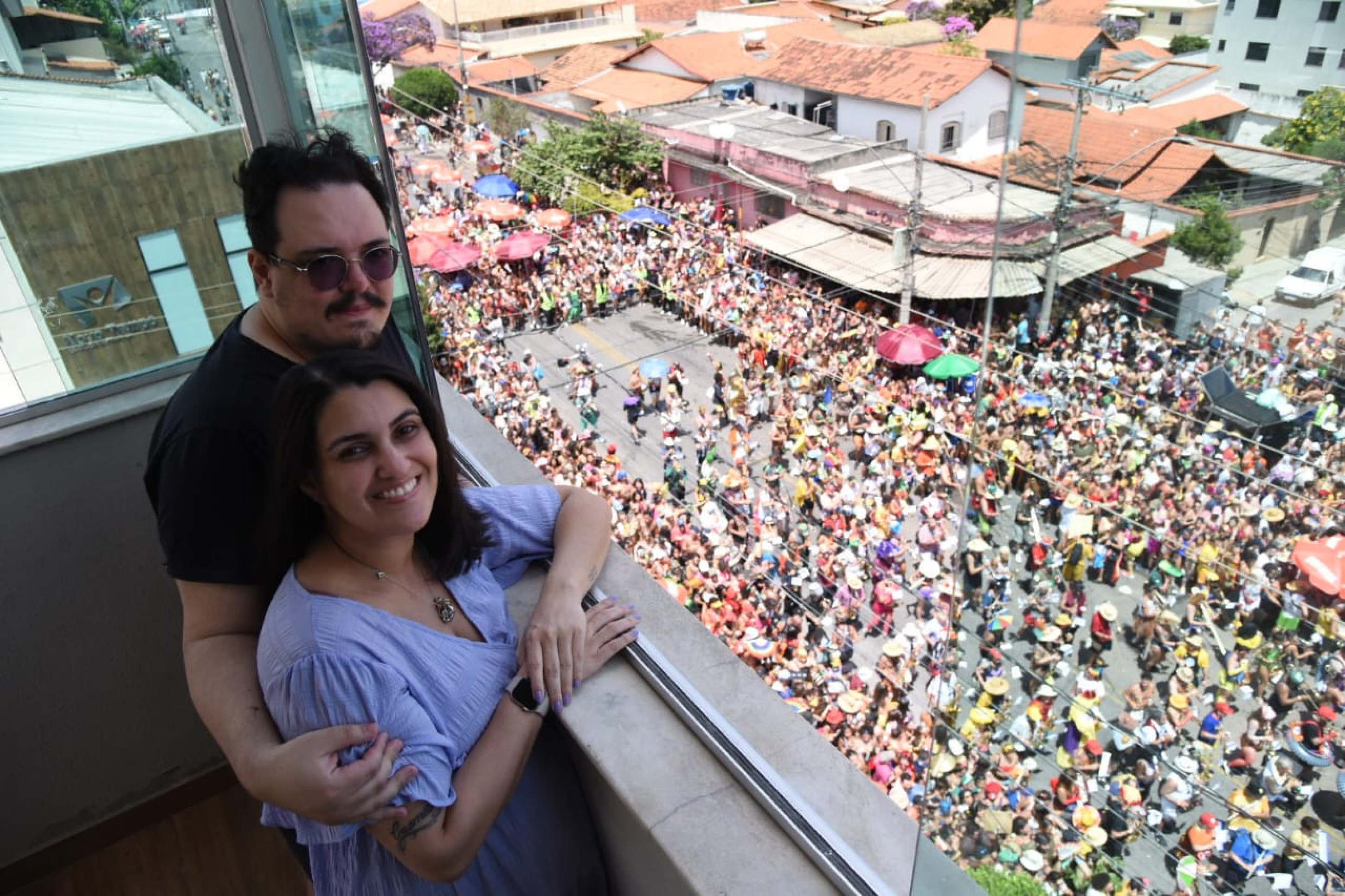Do alto do prédio, casal acompanha o desfile do Estagiários Brass Band