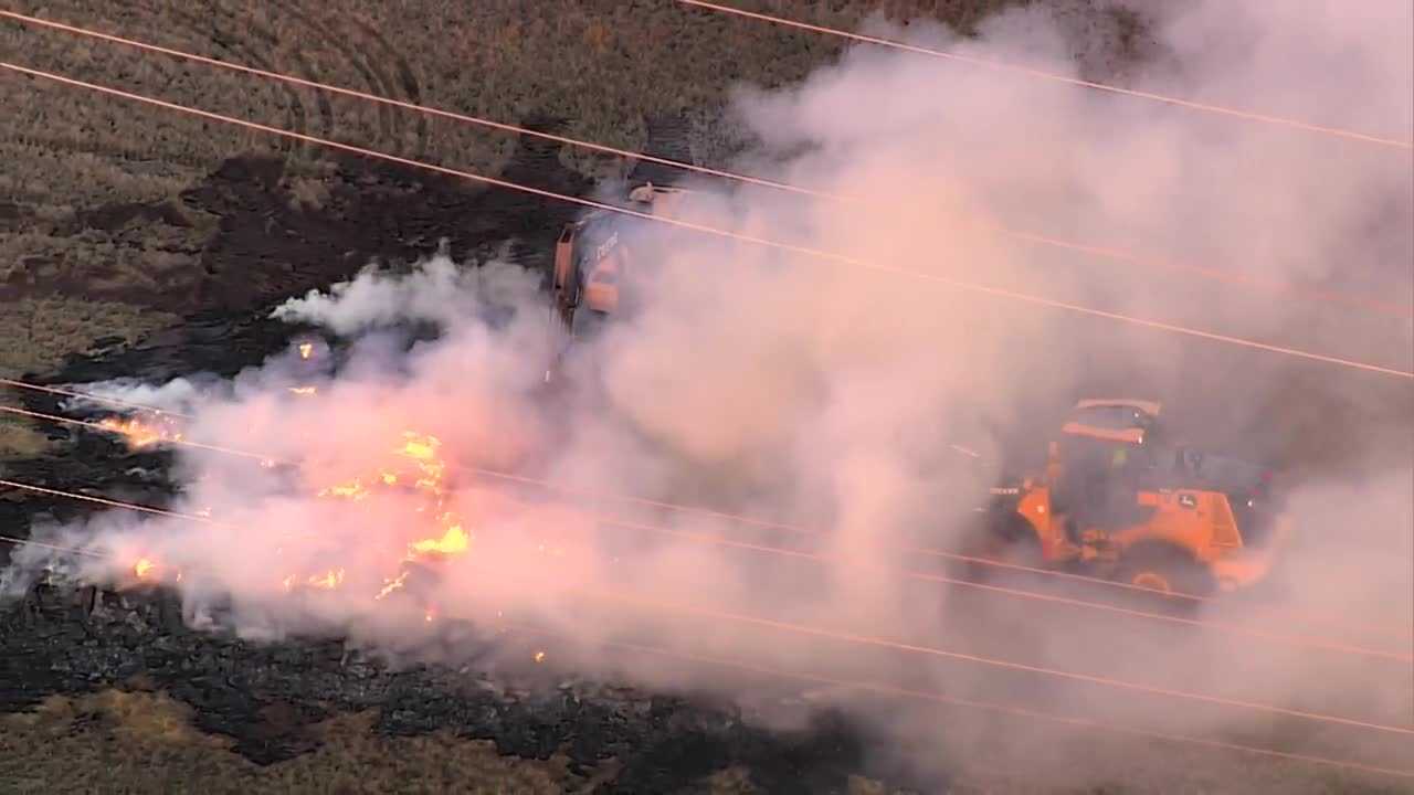 Norman crews use excavator to battle hay bale fire
