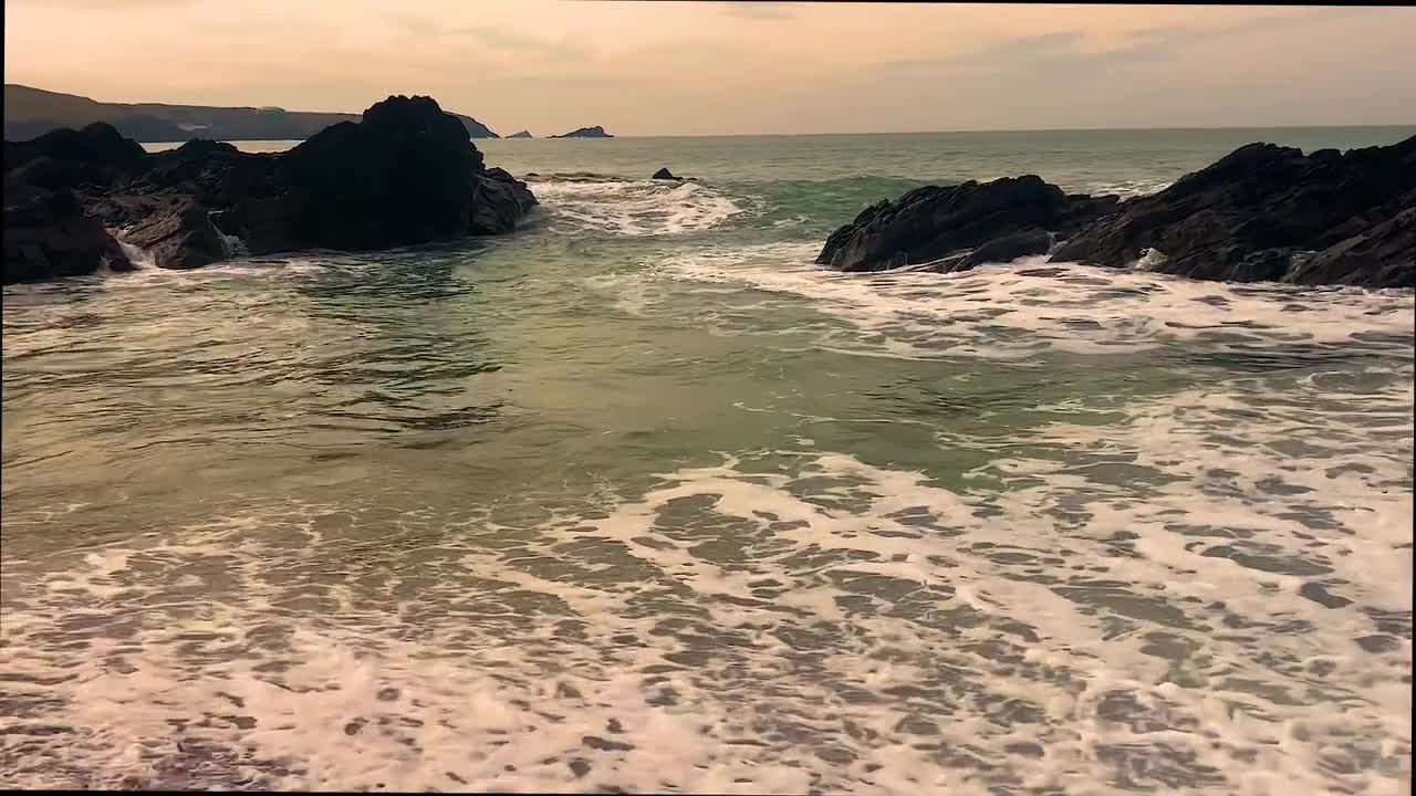 UK Travel, Waves slowly pound the shingle on a deserted idyllic sea ...