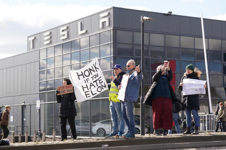 Protesters gathered outside Tesla dealership call for boycott