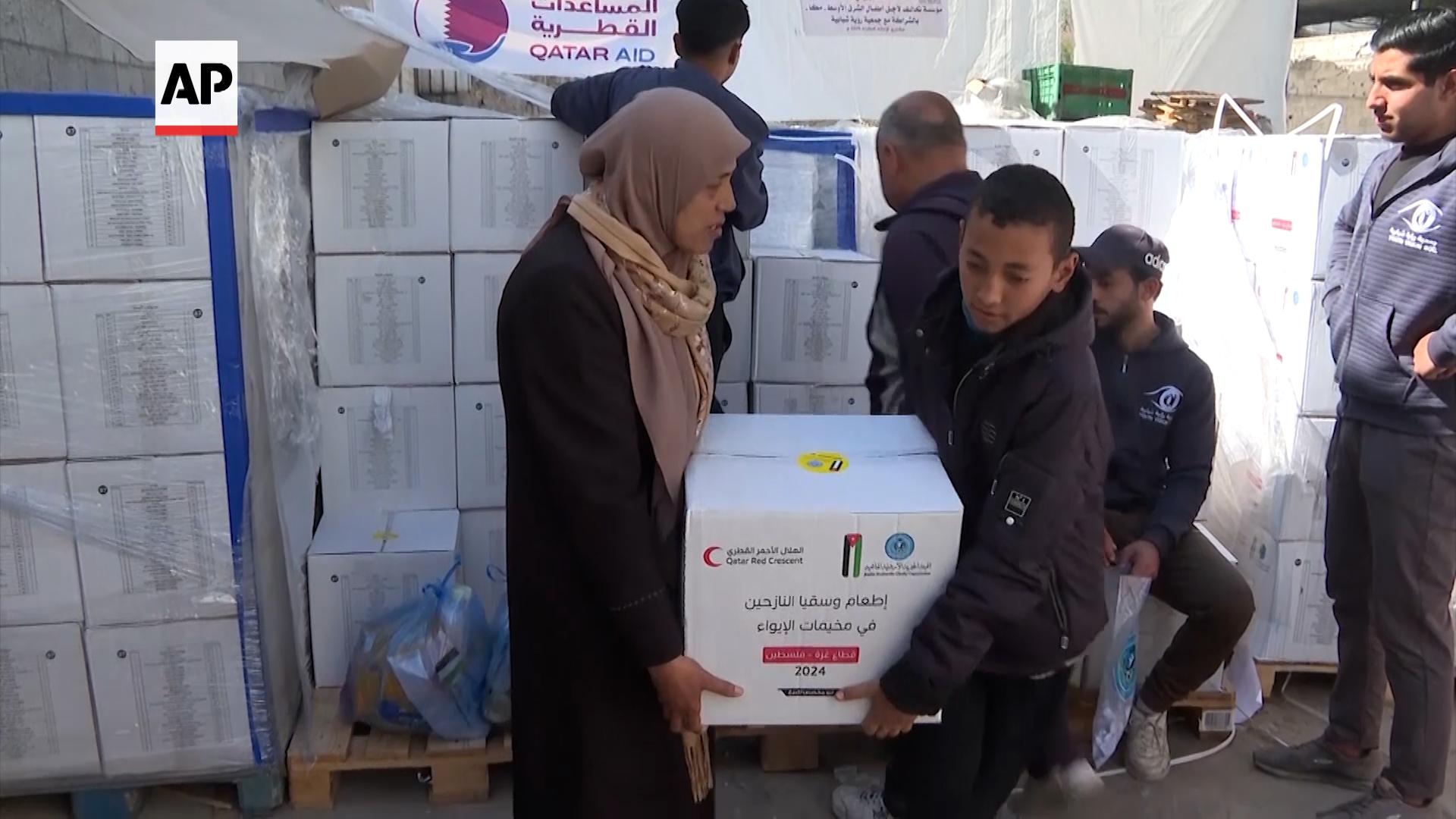 Palestinians line up to receive humanitarian aid after Israel stops aid ...