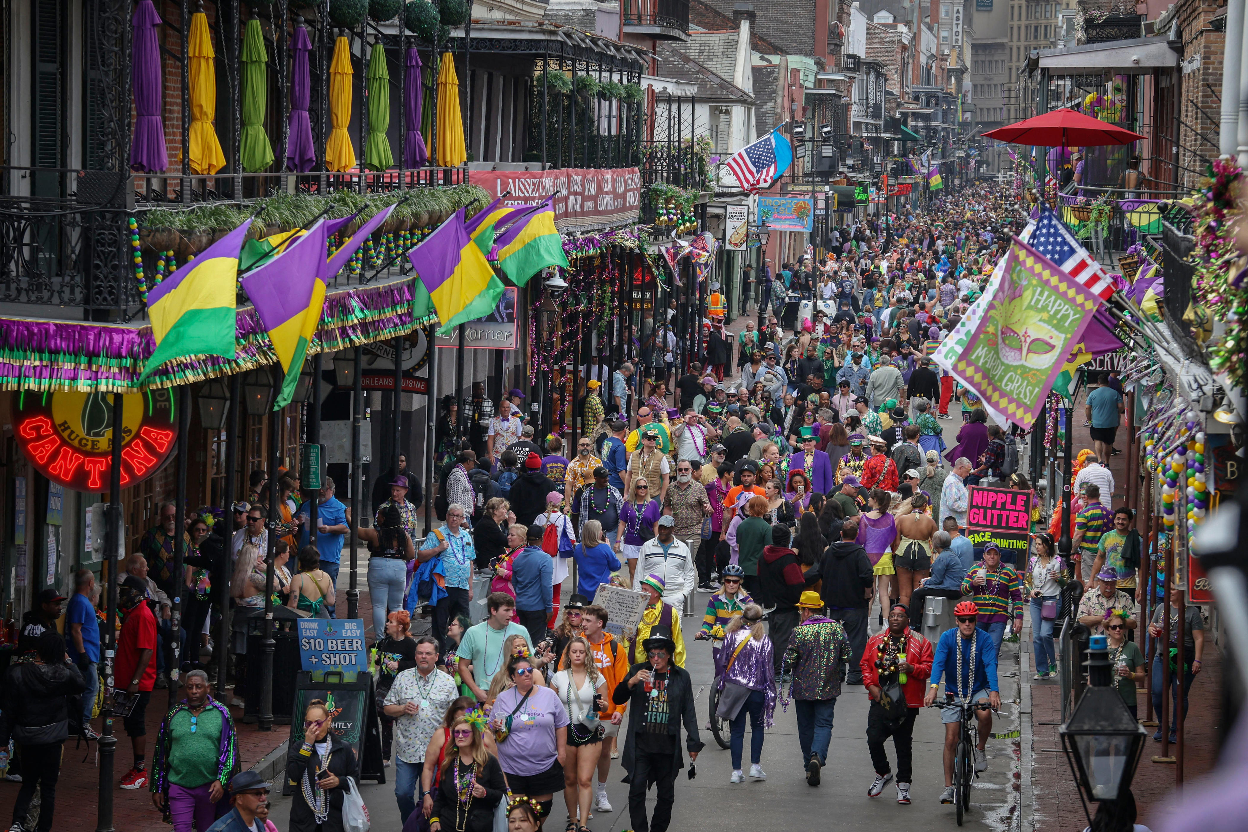 See spirited Mardi Gras revelers filling Bourbon Street with brilliant ...