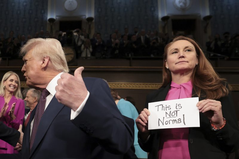 ‘This is not normal’: Who held up the protest sign before Trump’s speech?