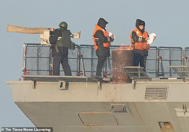 Russian officer brandishes machine gun on warship in the Channel
