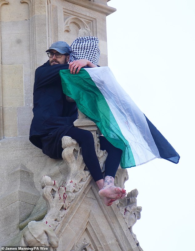 Barefoot protester is STILL up Big Ben after halting London route