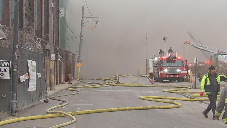 Firefighters monitoring remnants of massive blaze at waste building in ...