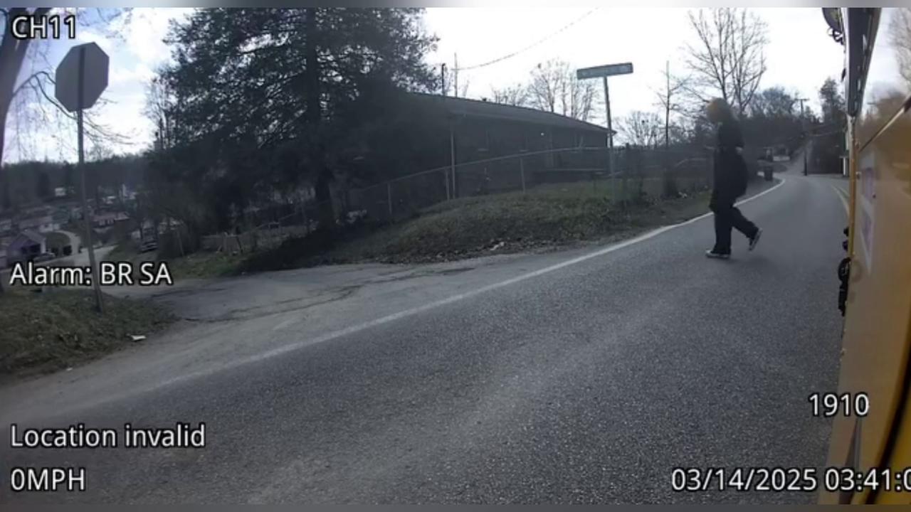 Pupil steps out from school bus narrowly avoiding oncoming car