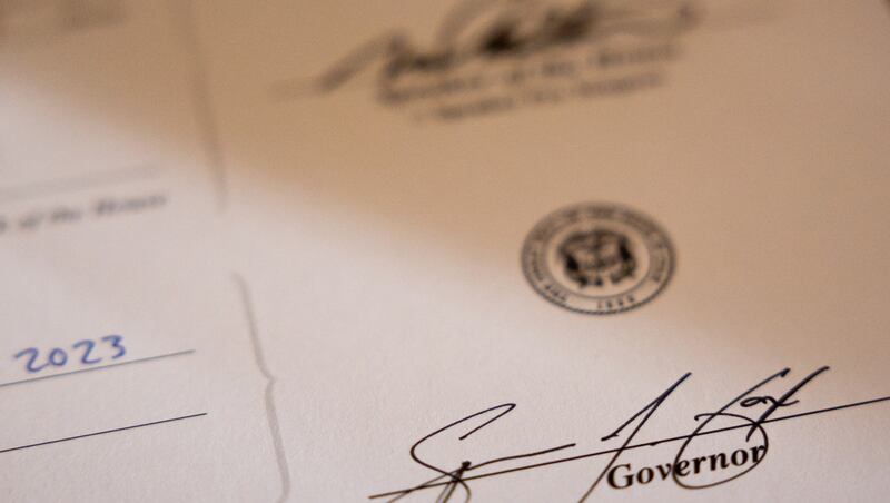 Governor inks $127M income tax cut, bill phasing out automatic vote-by-mail