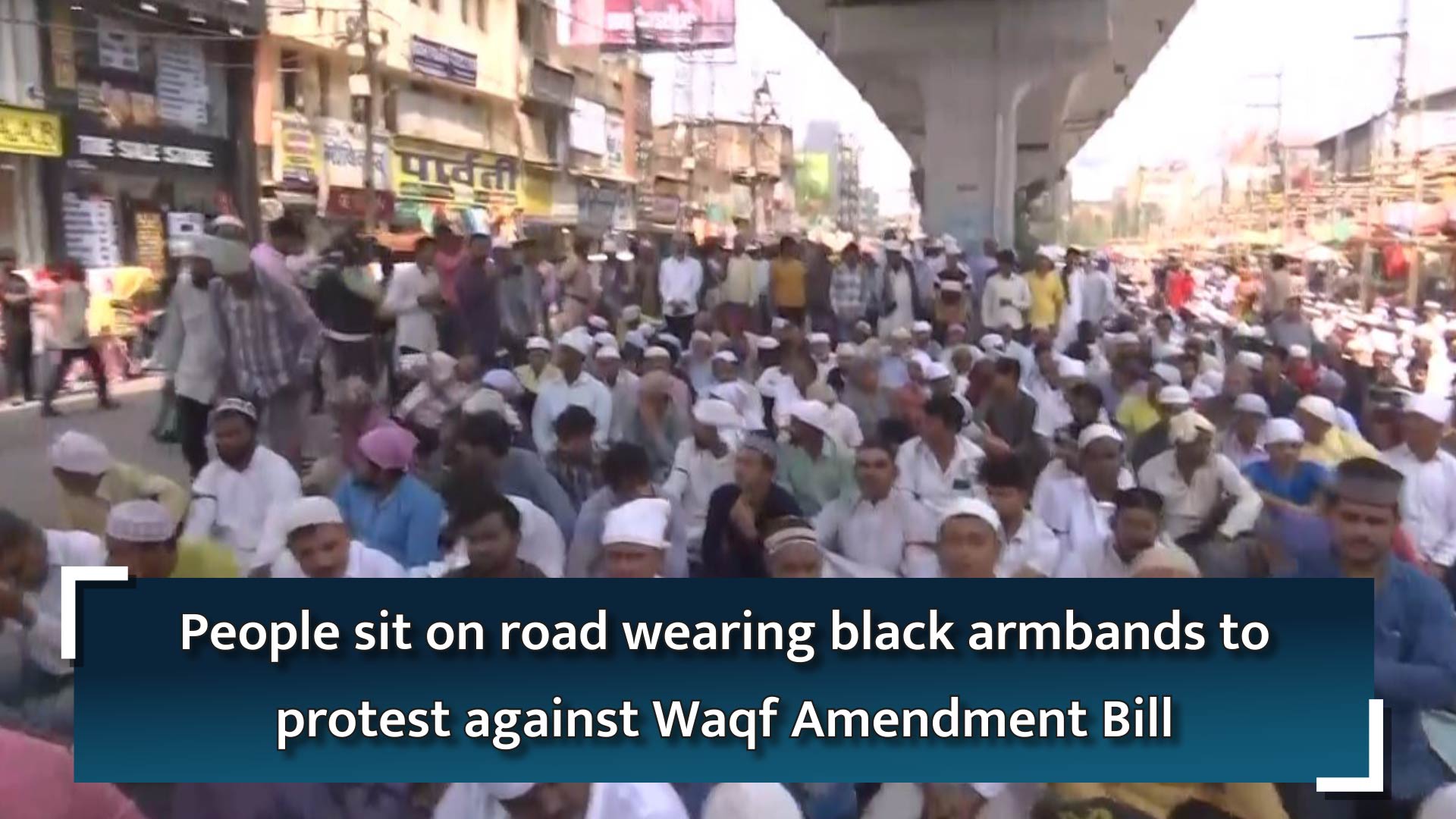 People sit on road wearing black armbands to protest against Waqf ...