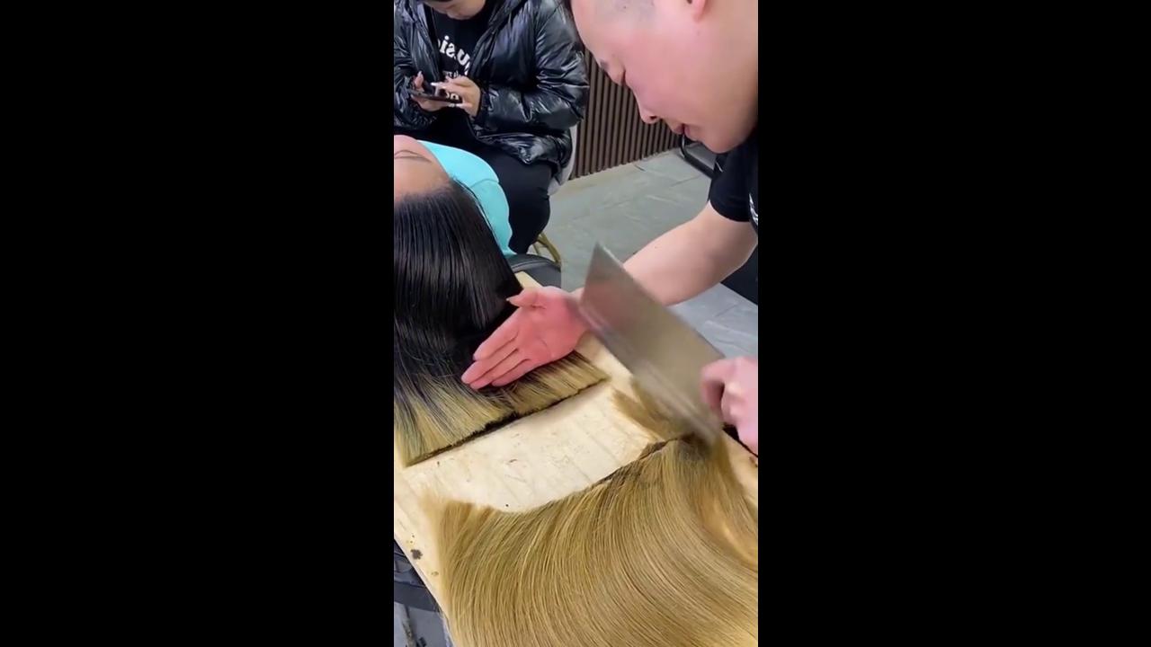 Chinese hairdresser cuts hair with a kitchen chopping knife
