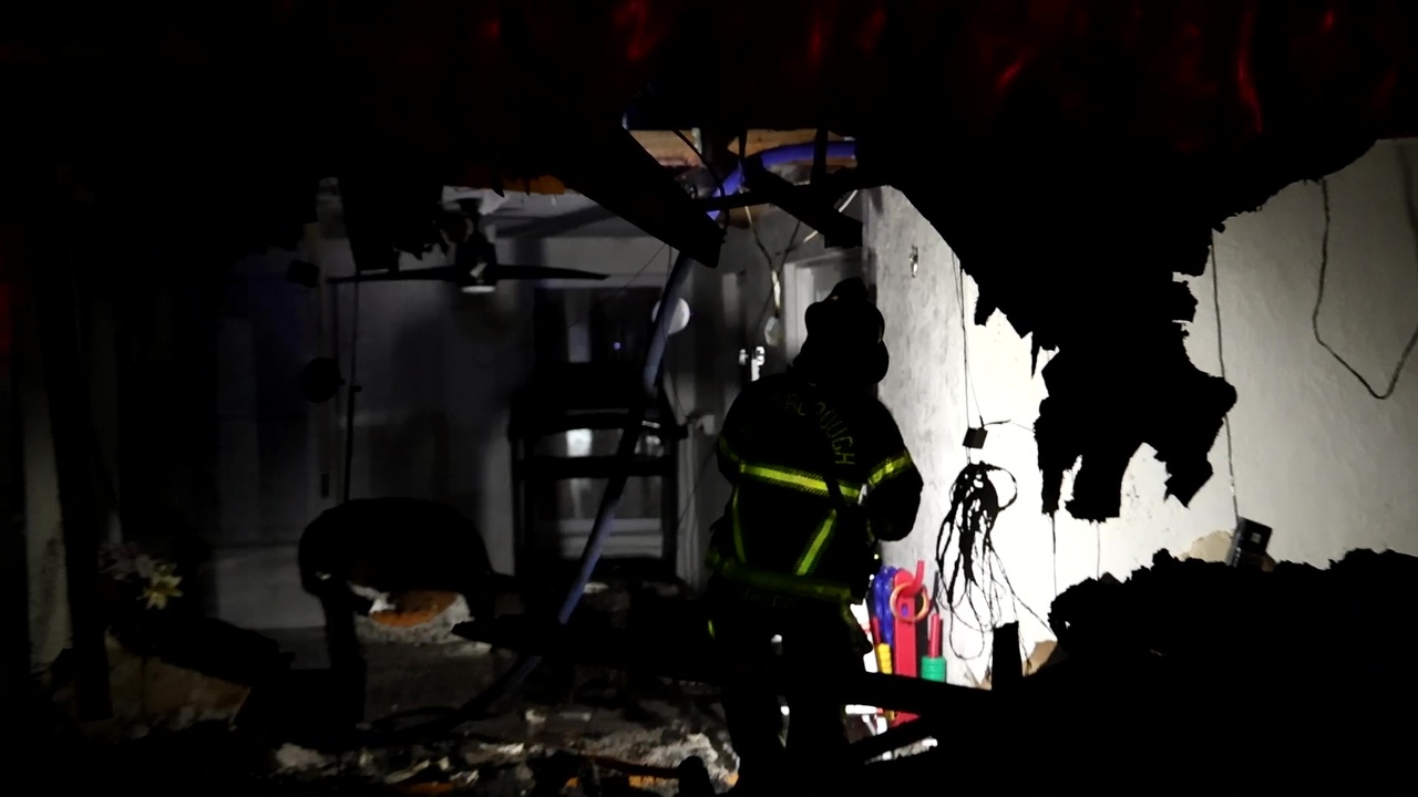 Firefighter surveys damage left by Tampa house fire