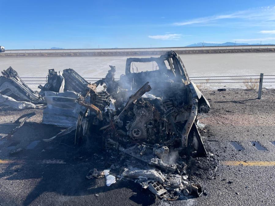 Driver injured, car catches fire after crashing into back of semi-truck