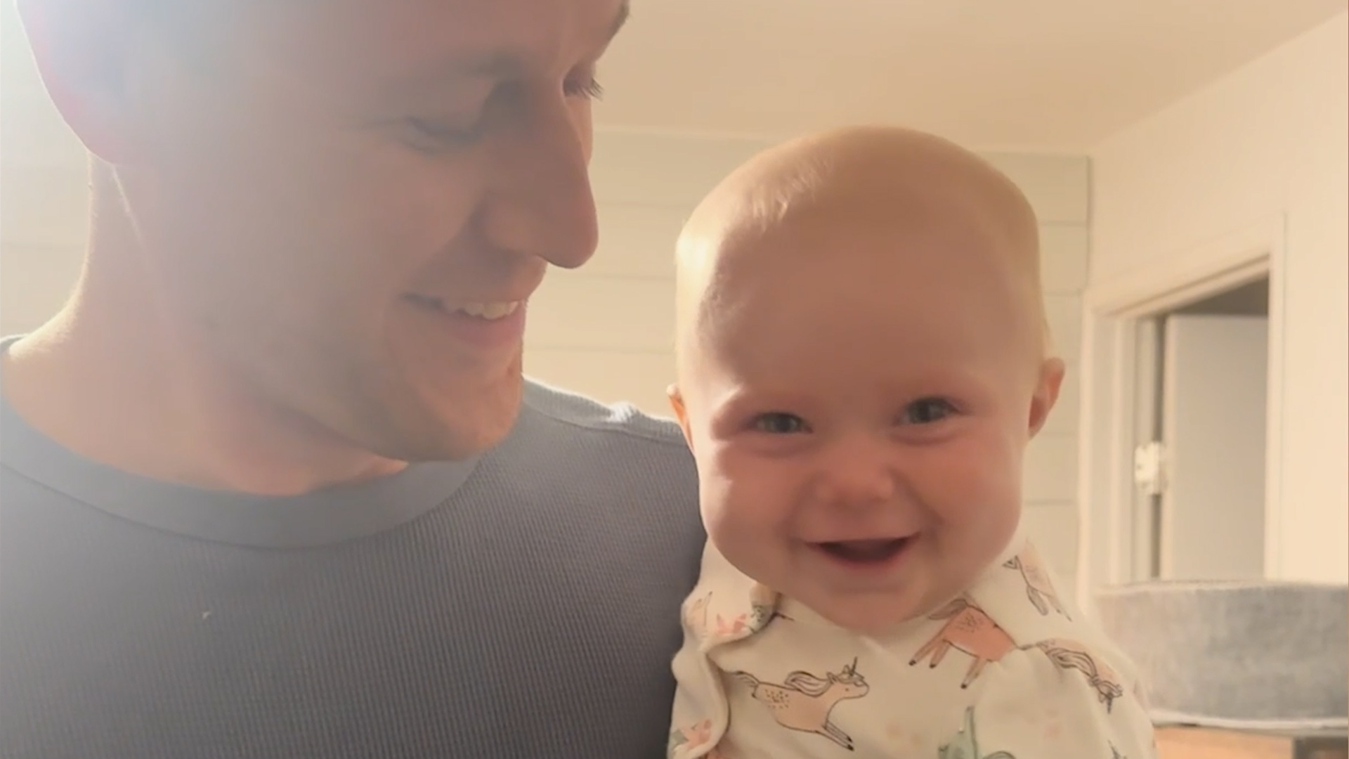 Mischievous baby grins with pride after stealing dad's shirt