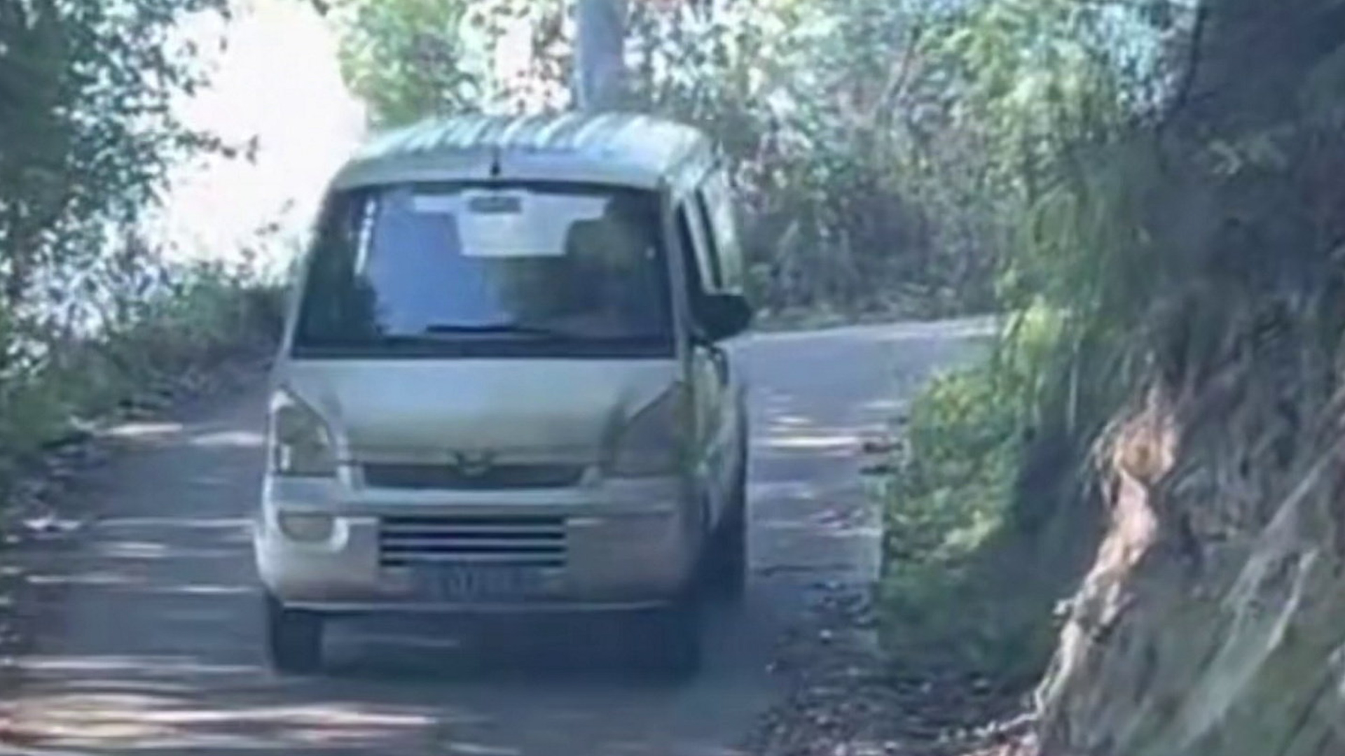 Daring driver reverses at speed along narrow winding mountain road