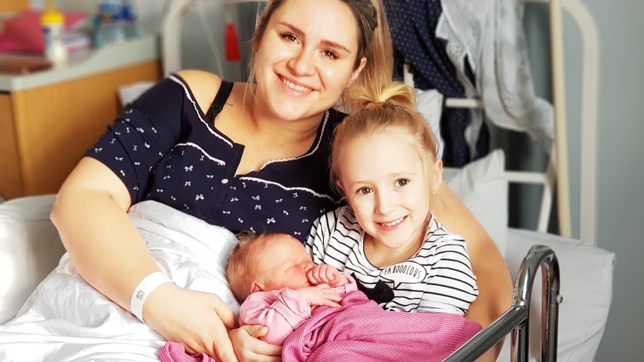Little girl meets baby sister while dogs watch