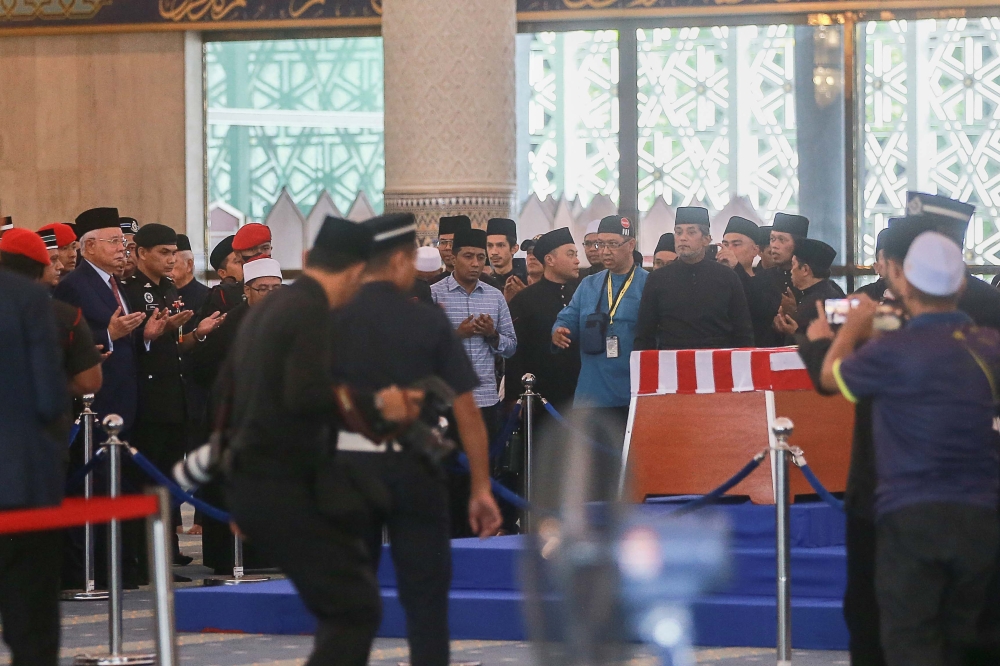 Clad in black, prisoner Najib quietly attends Abdullah Badawi’s funeral after court grants ...