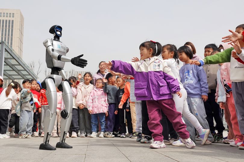Pareja de robot humanoide y perro camina por la pasarela en un desfile ...
