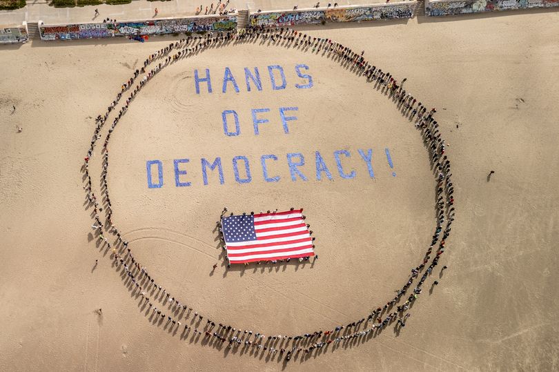 Protesters rally on California beach with 'Hands Off!' human banner ...