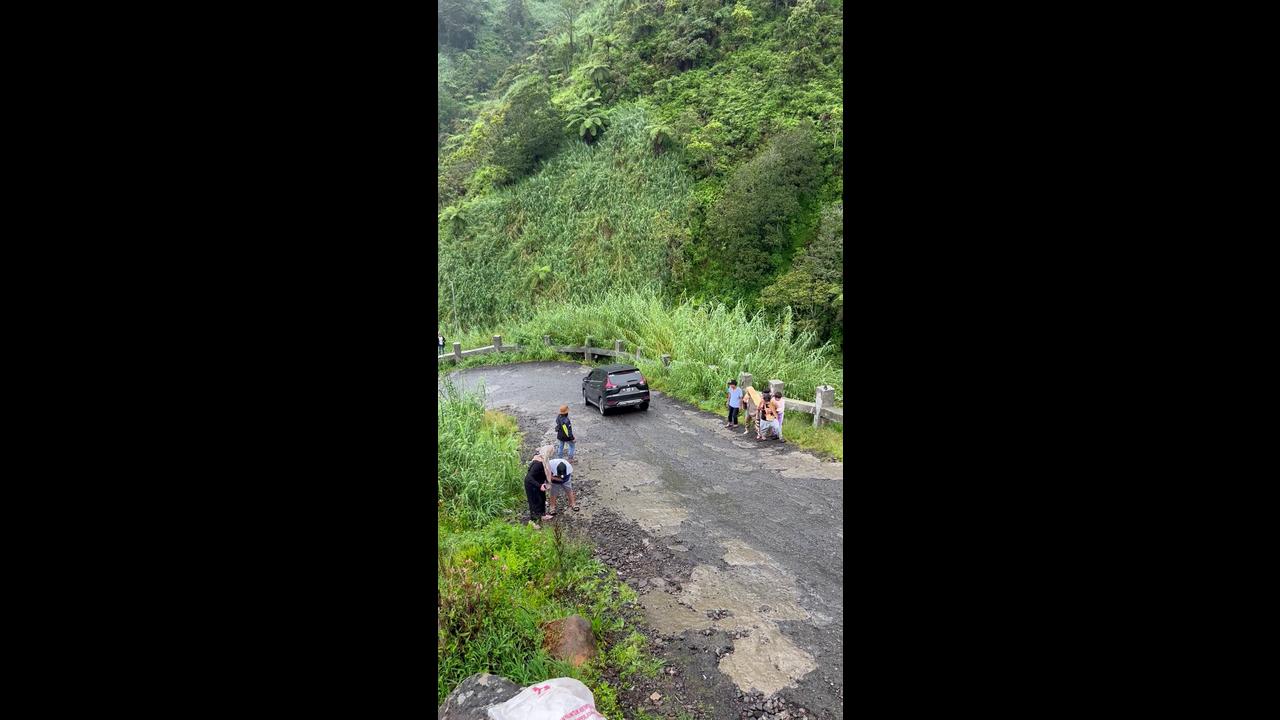 Driver reverses up steep mountain road in Indonesia
