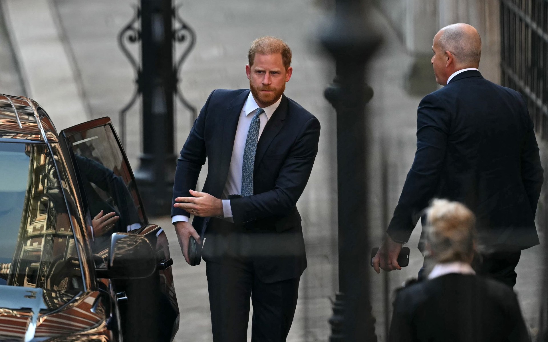 Prince Harry throws peace sign as he enters court in surprise UK visit