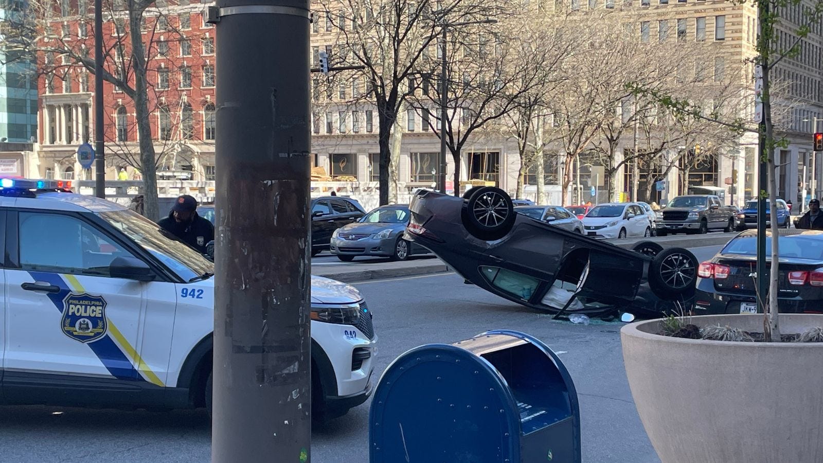 Officer injured after car slams into parked police vehicle, flips on ...