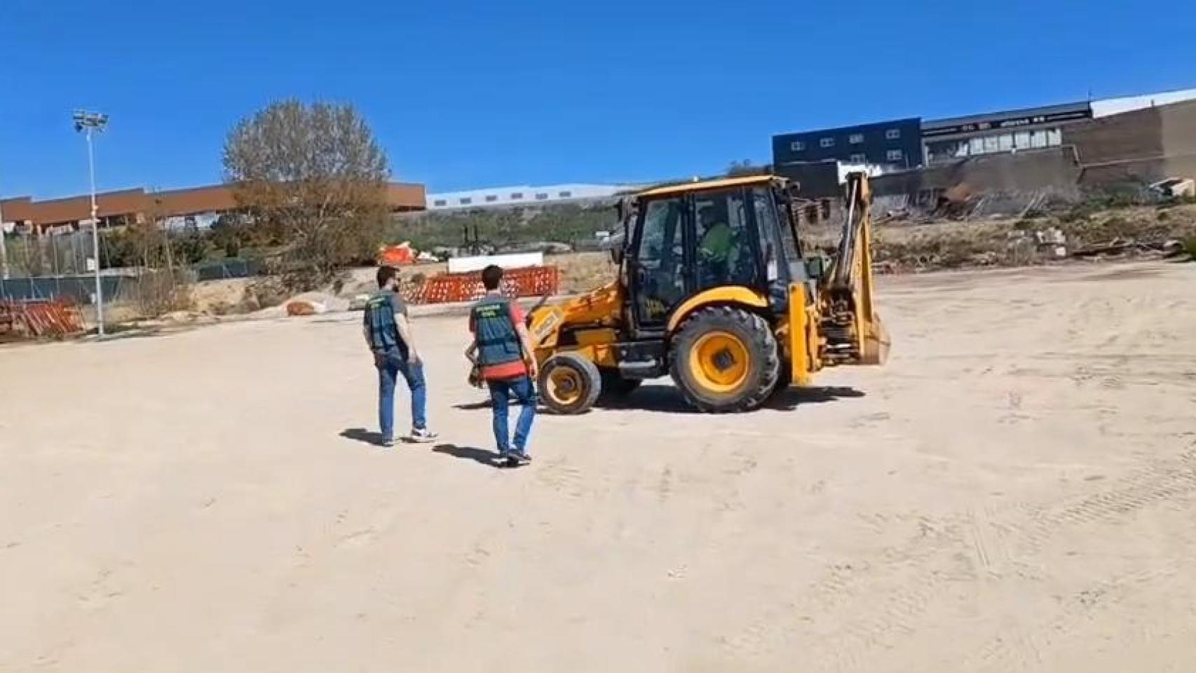 Agentes de la Guardia Civil inspeccionando la excavadora.