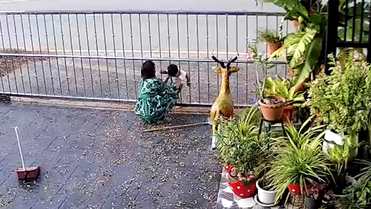Toddler gets his head stuck while climbing through driveway gate