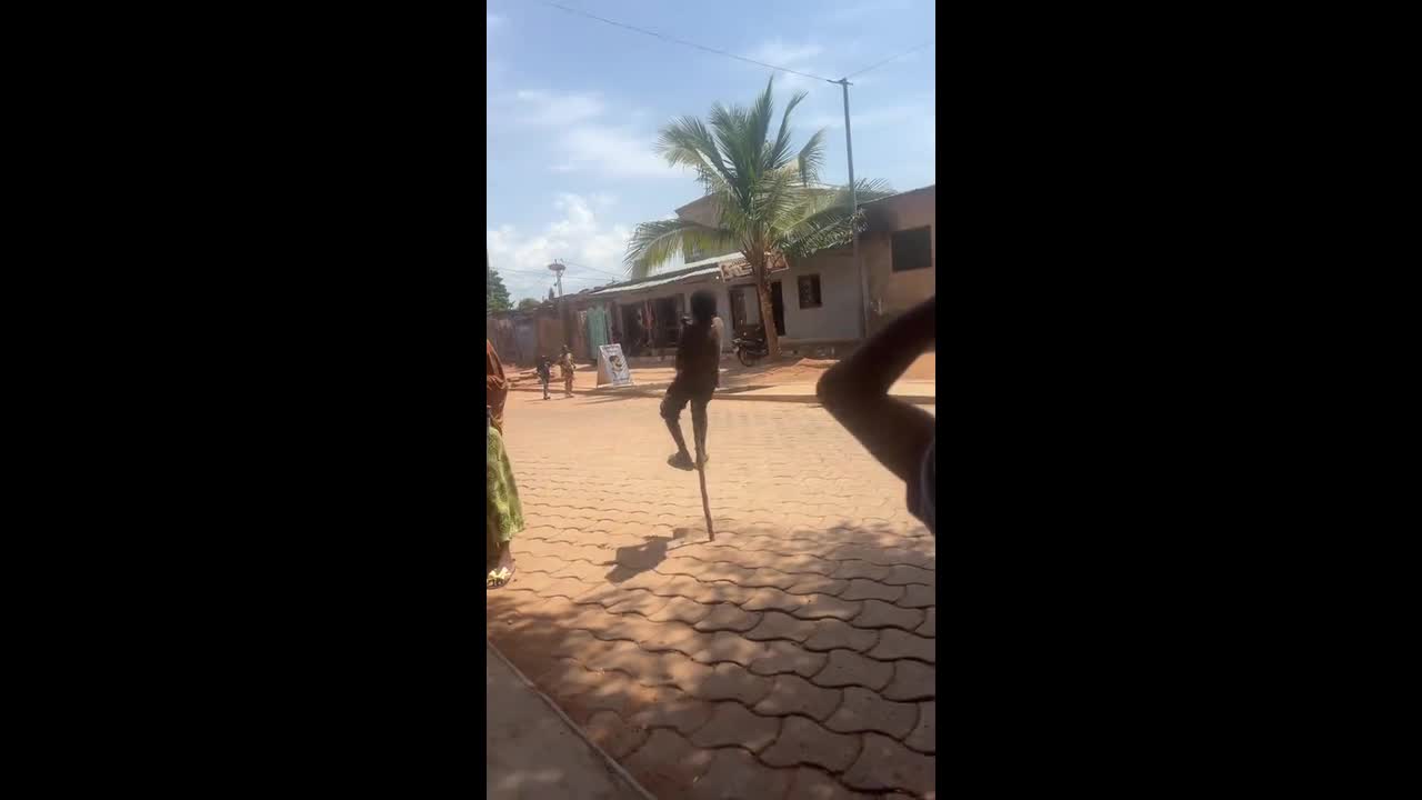 Children in Parakou hop with single stick to show their culture