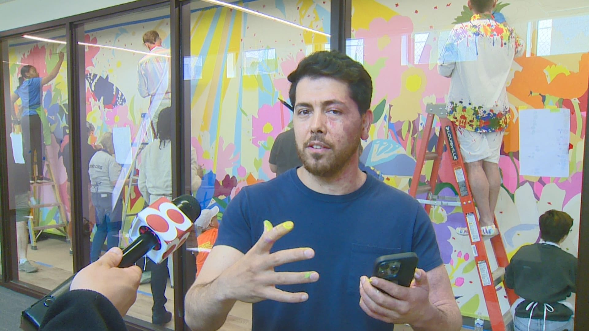Dozens help paint new mural at the Damien Center