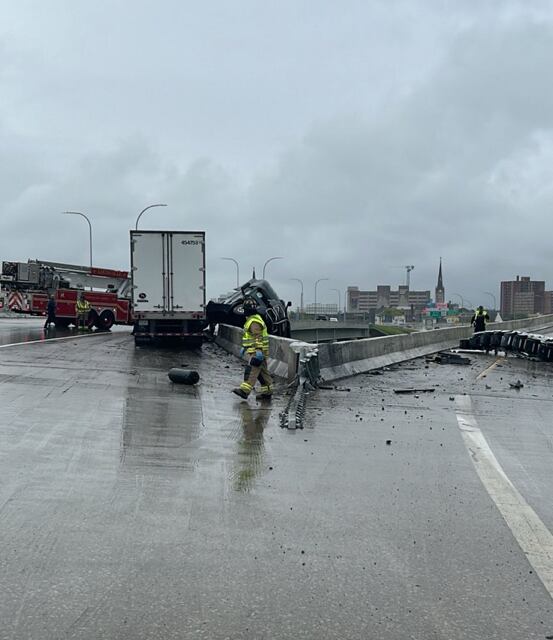 Driver rescued after crash leaves semi-truck cab dangling over overpass ...
