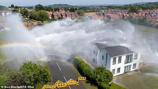 Burst pipe sends send thousands of gallons of water towering 100ft into ...