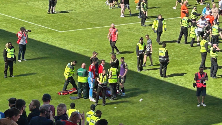 Footballer hit in the head by seat thrown from stands by own fans