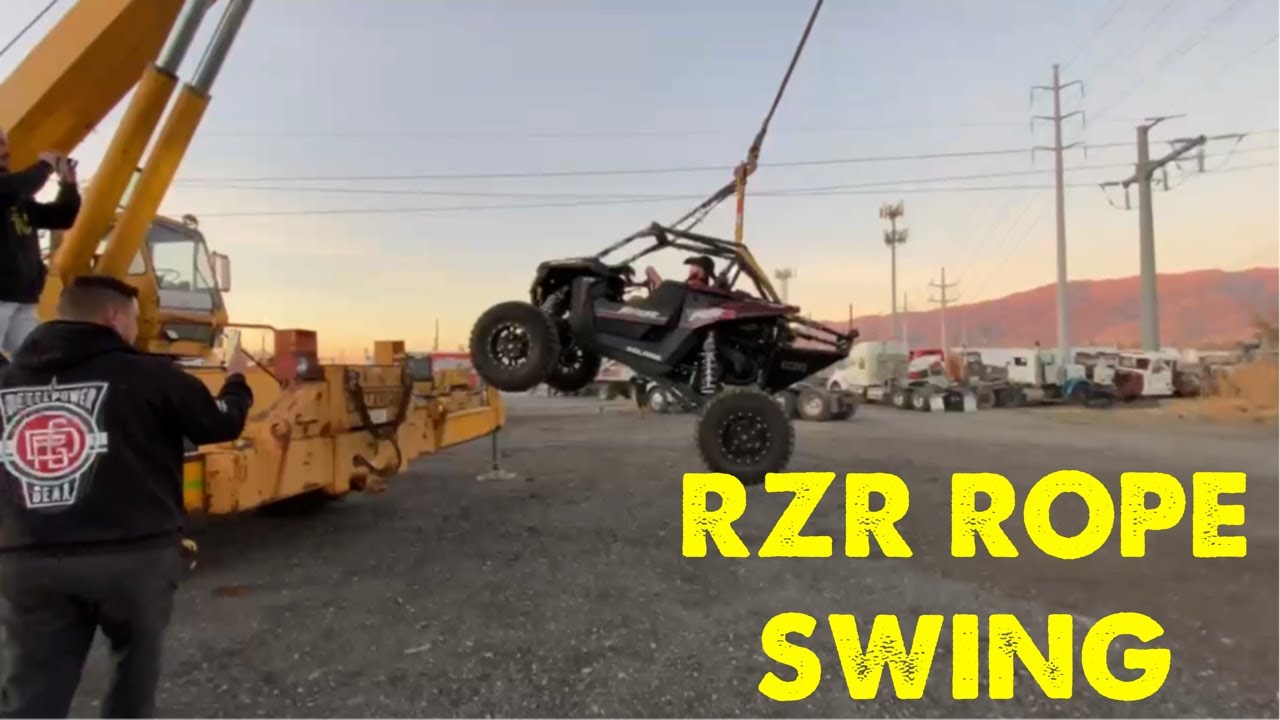 A Polaris RZR swings from a crane in a risky stunt