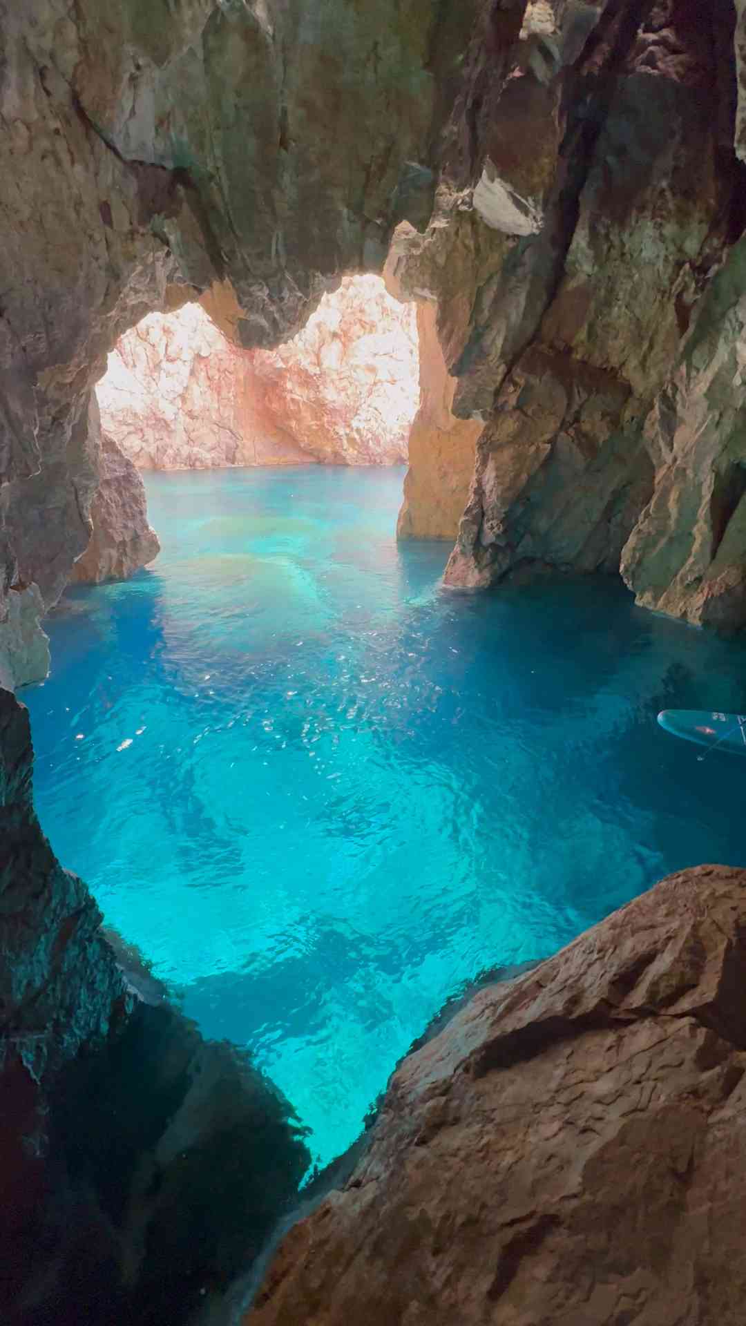 Stand Up Paddleboarding Through a Stunning Sea Cave with Crystal Blue Water