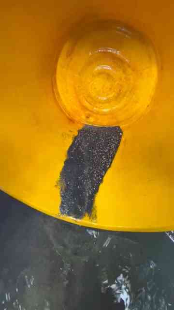 A traditional gold miner is separating gold from iron sand without ...