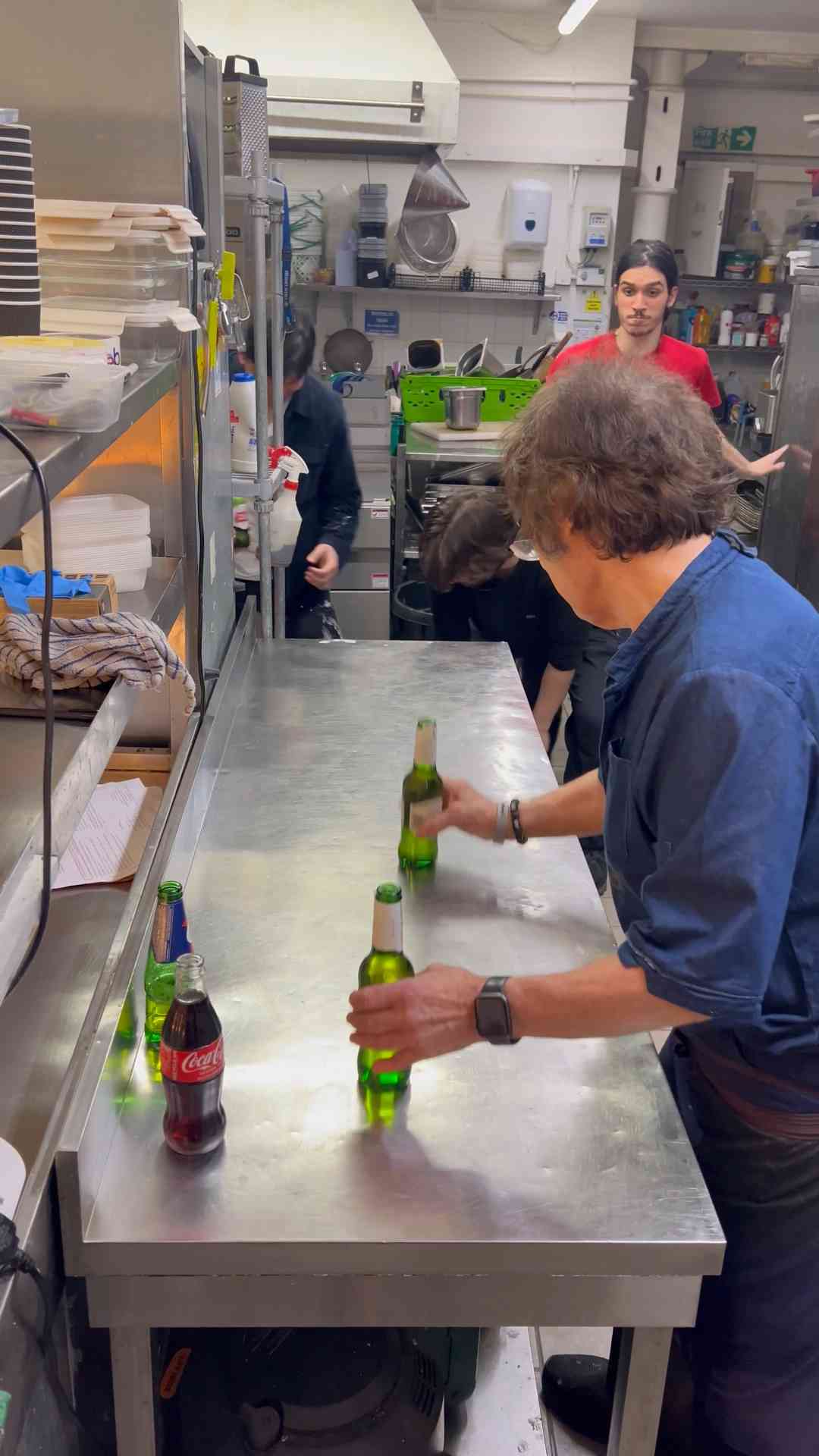 Chef Sliding Beers to Staff in a Busy Kitchen