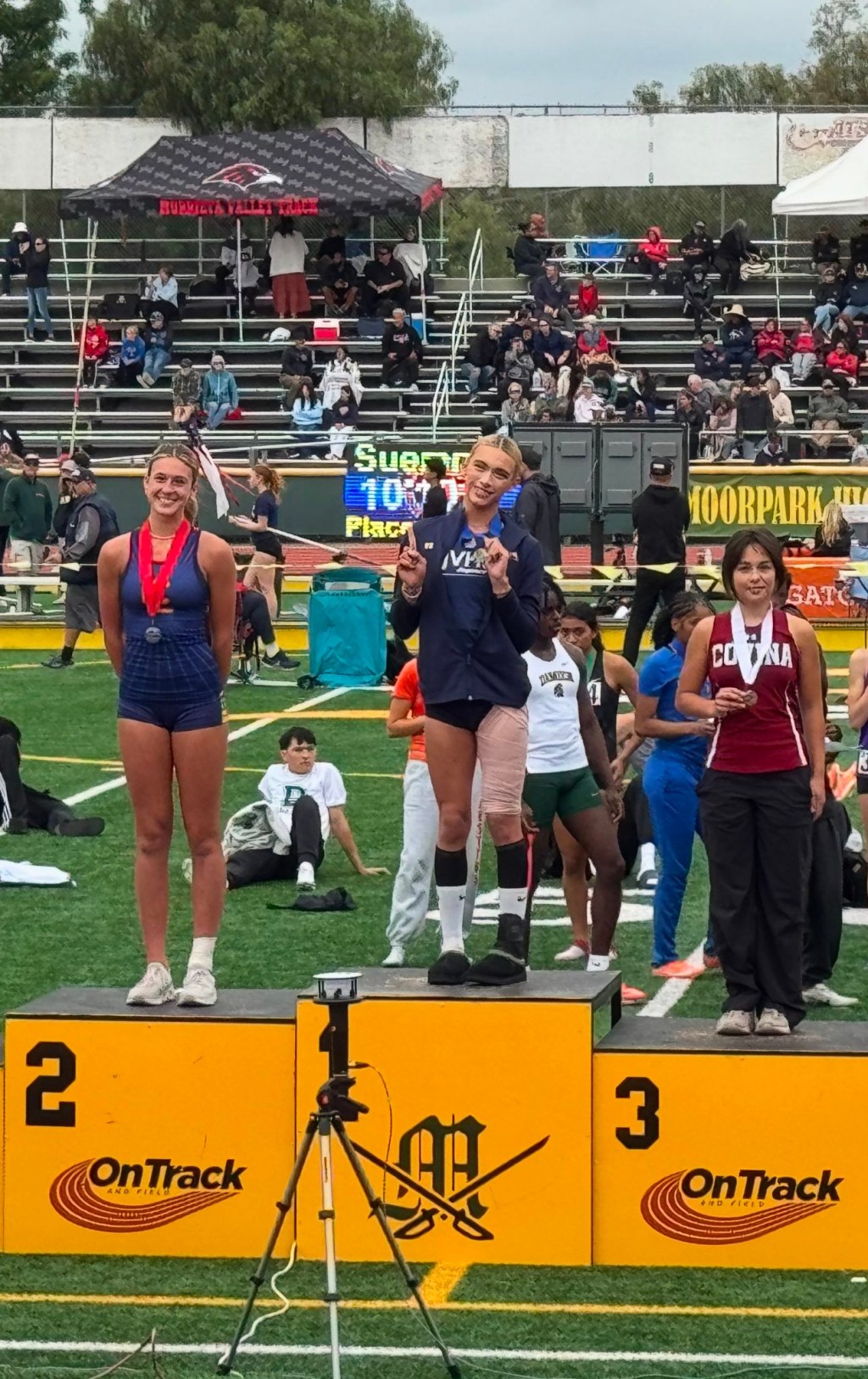 High school female track star poses on first-place podium after ...