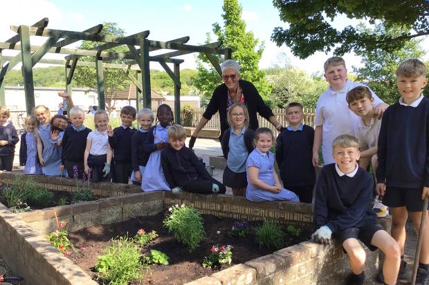 Schoolchildren brighten up their playground with flowers and plants