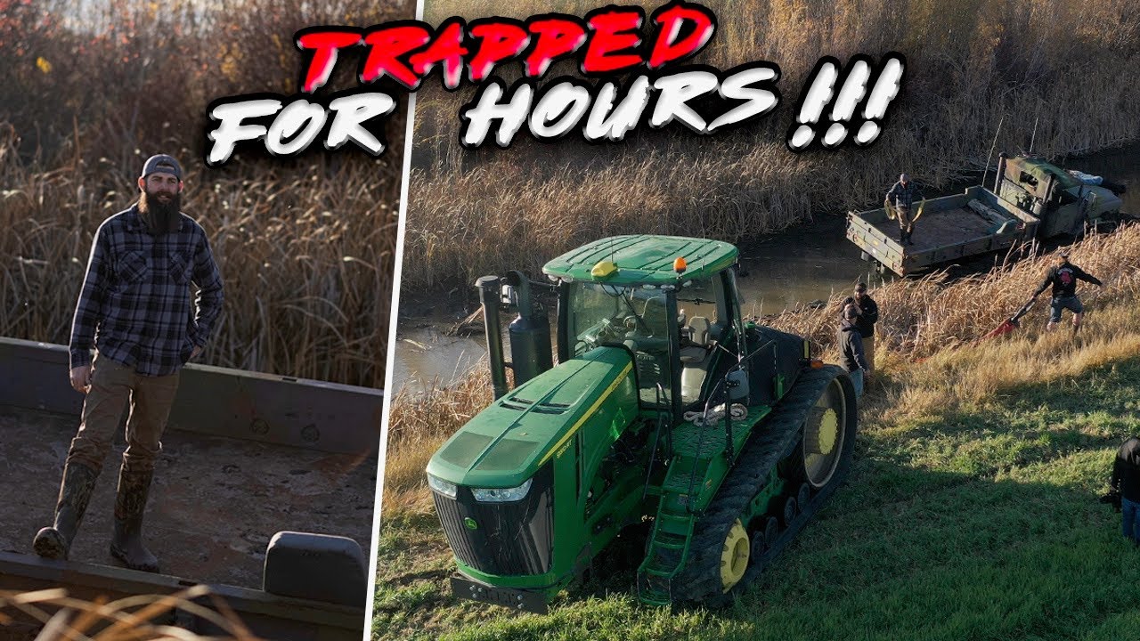 A John Deere tractor attempts a flooded army truck recovery