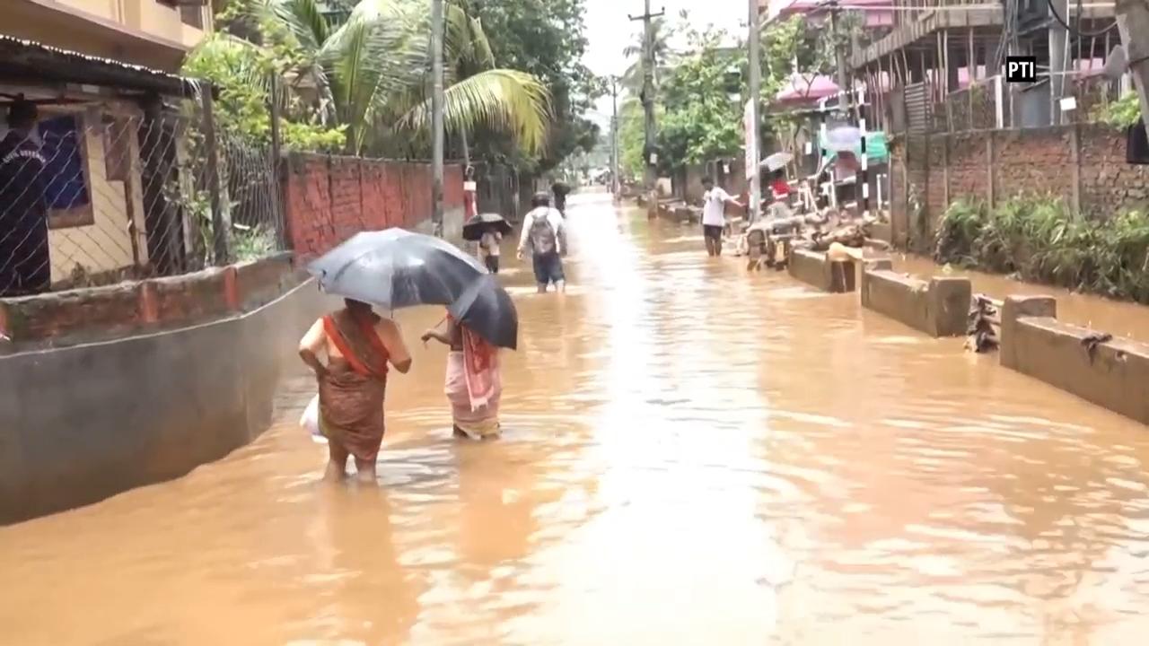 People wade through flood waters as India's Assam state is hit by ...