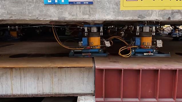 Hundreds of tiny robots move 7,400 tonne building complex