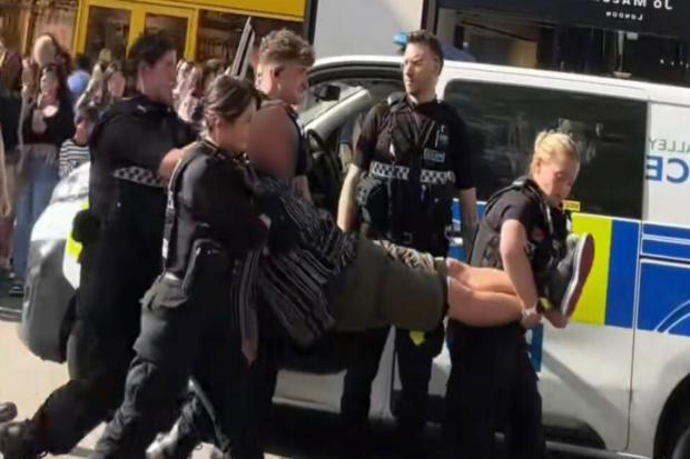 Video shows crowds watching as person carried away by police outside ...
