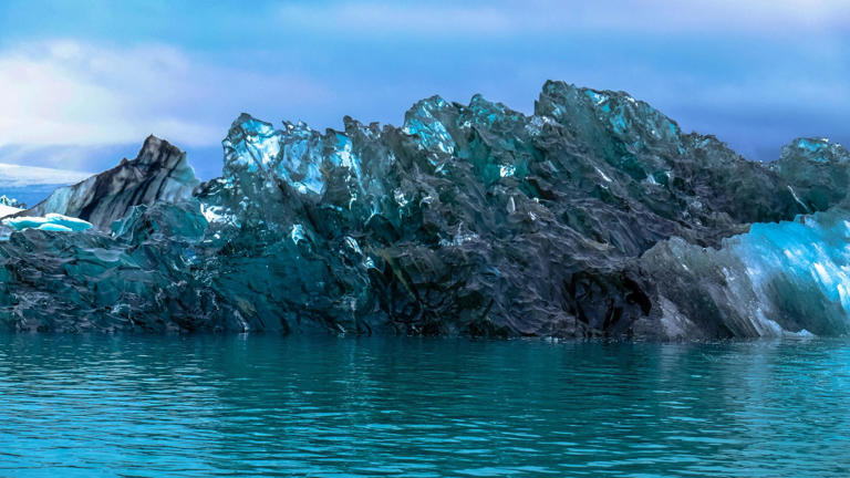 Et svart isfjell dukker opp av vannet: mysteriet som fascinerer selv ...