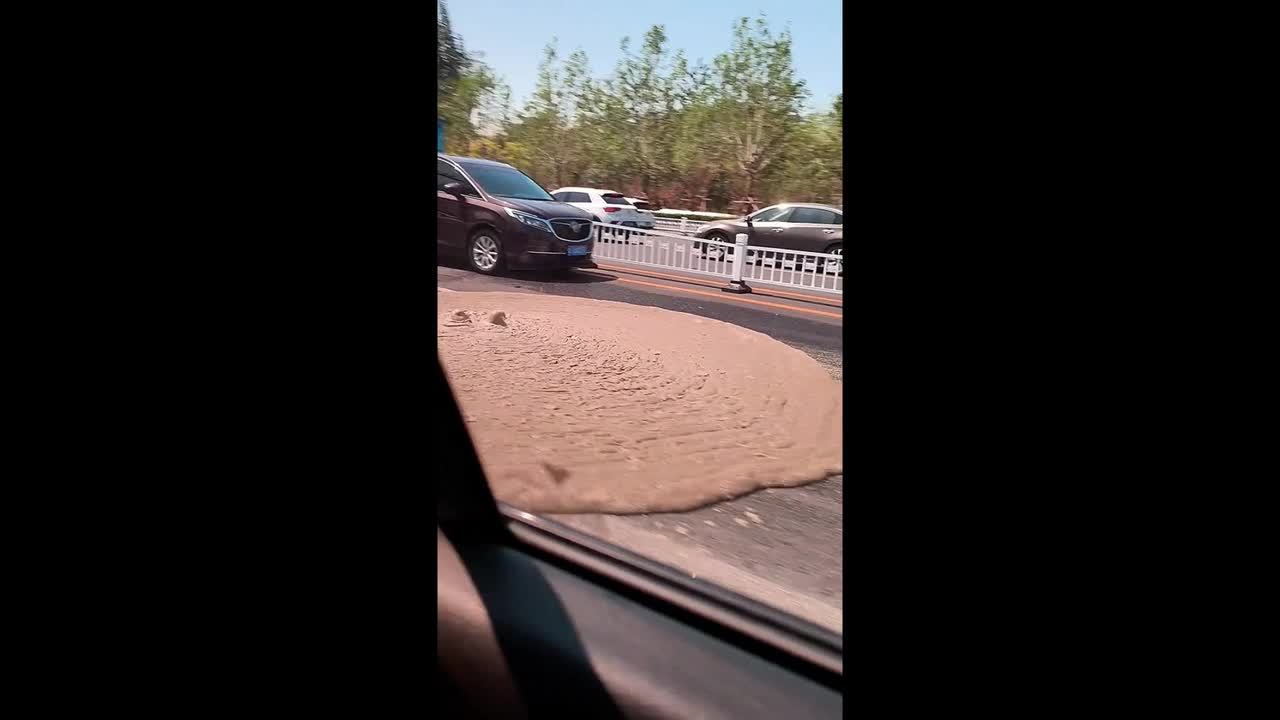 A road in Tianjin suddenly spewed out a large amount of mud that looked ...