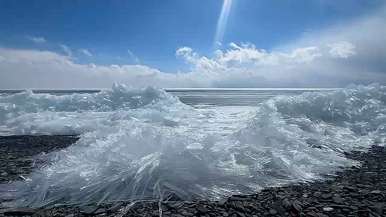 Mesmerizing crystalline ice sheets shatter as they push onto shore in China