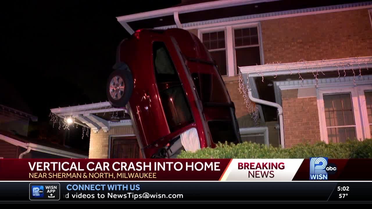 Car lands vertically against home after crash in Milwaukee