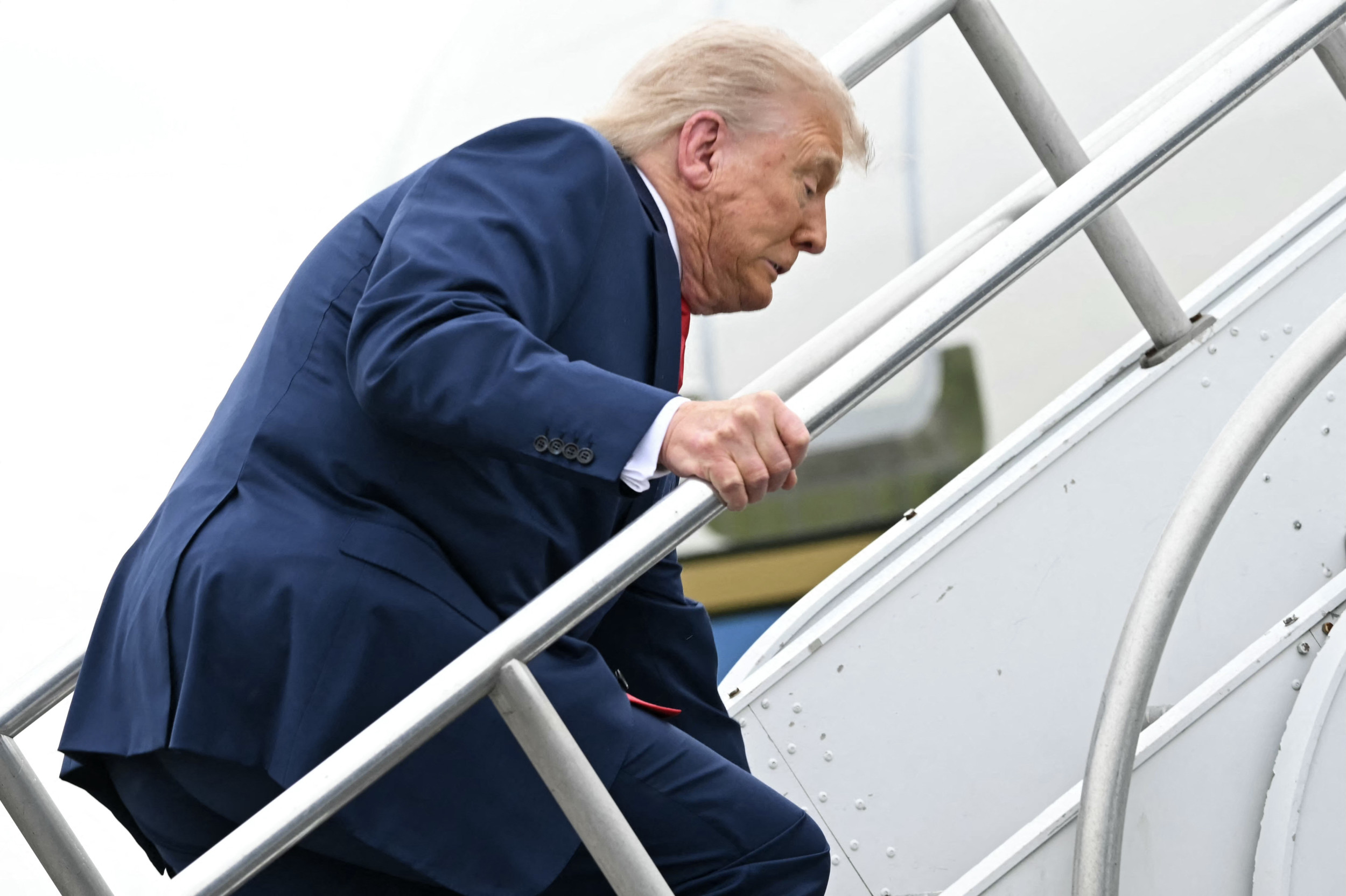 Donald Trump stumbles on plane stairs