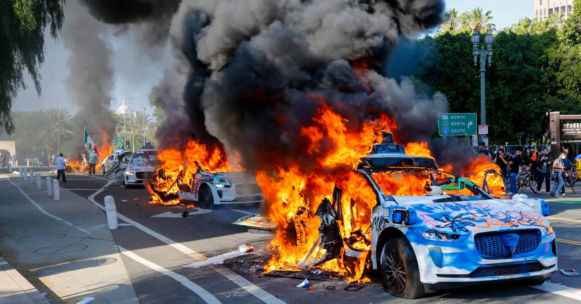 Photos show Waymo vehicles on fire during LA protests as company cuts ...