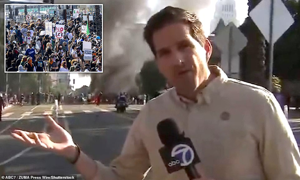 Reporter denies there are riots in LA while chaos unfolds behind him