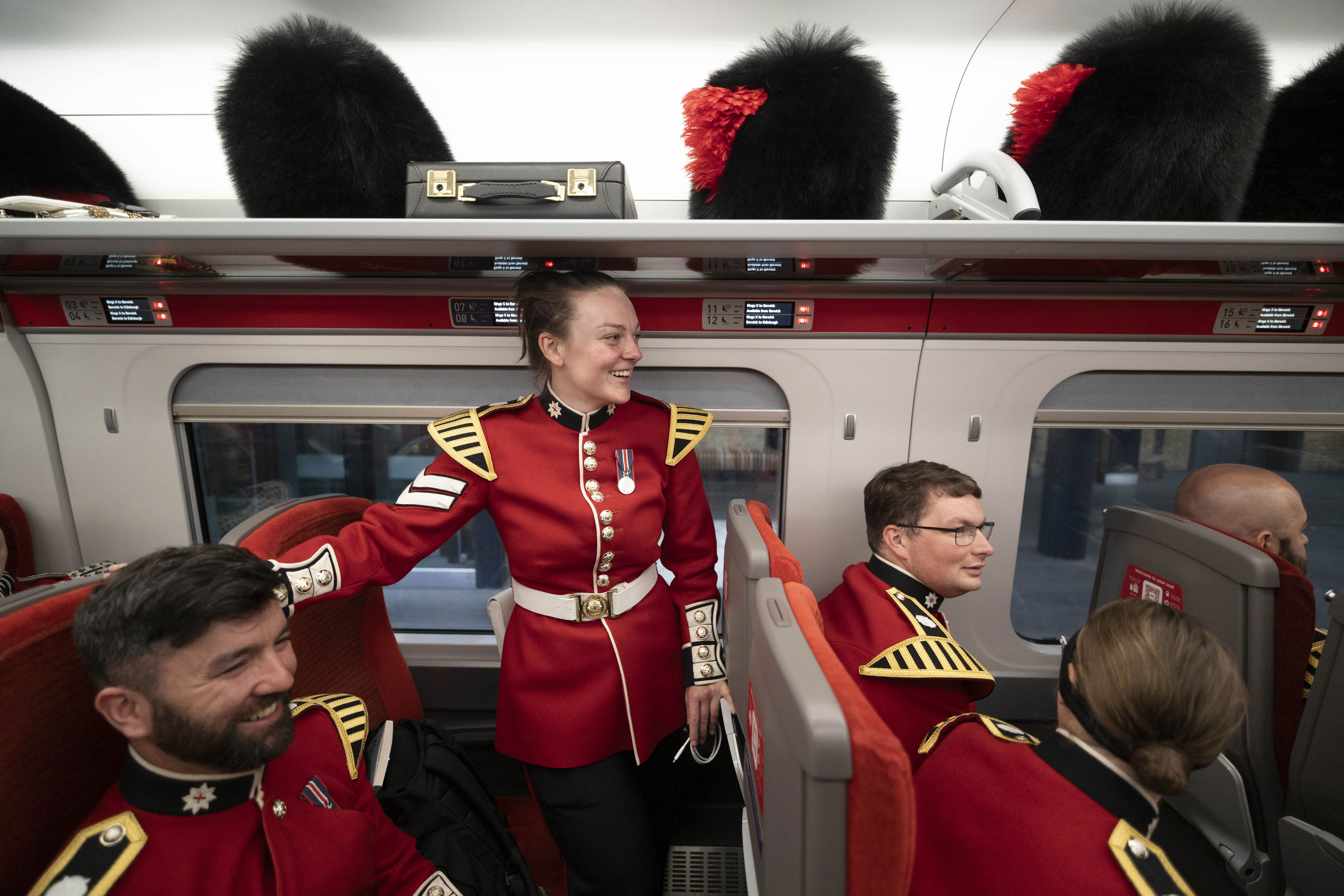 In Pictures: Bearskin caps in the luggage rack as Coldstream Guards ...